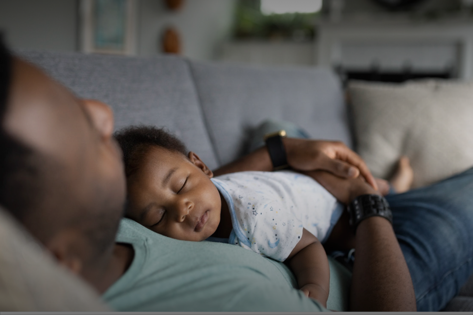 Background image with a baby in his father's arms while he sleeps